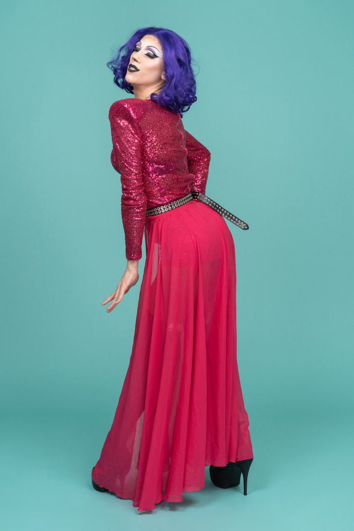 Back view of a drag queen in pink dress arching their back with eyes ...