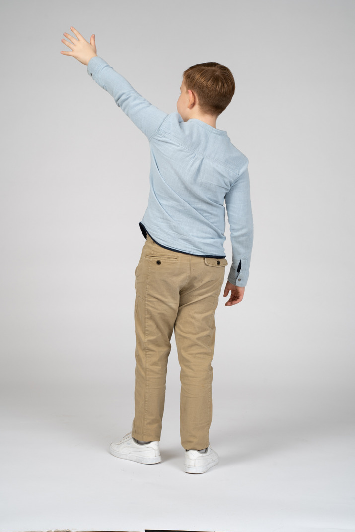 Back view of a boy waving Photo
