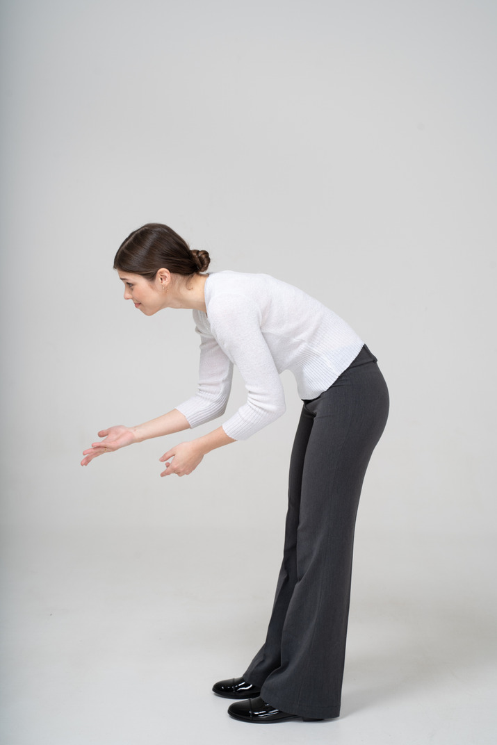 Side view of a woman bending down and explaining something to someone Photo