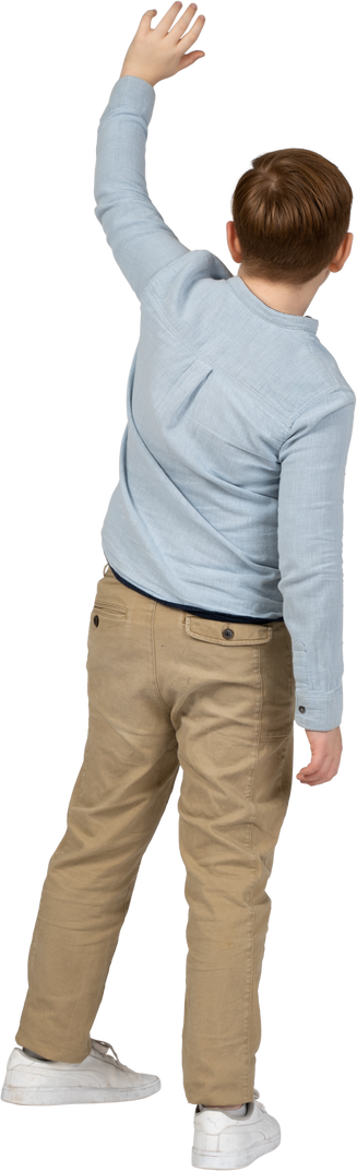 Back view of a boy waving Photo
