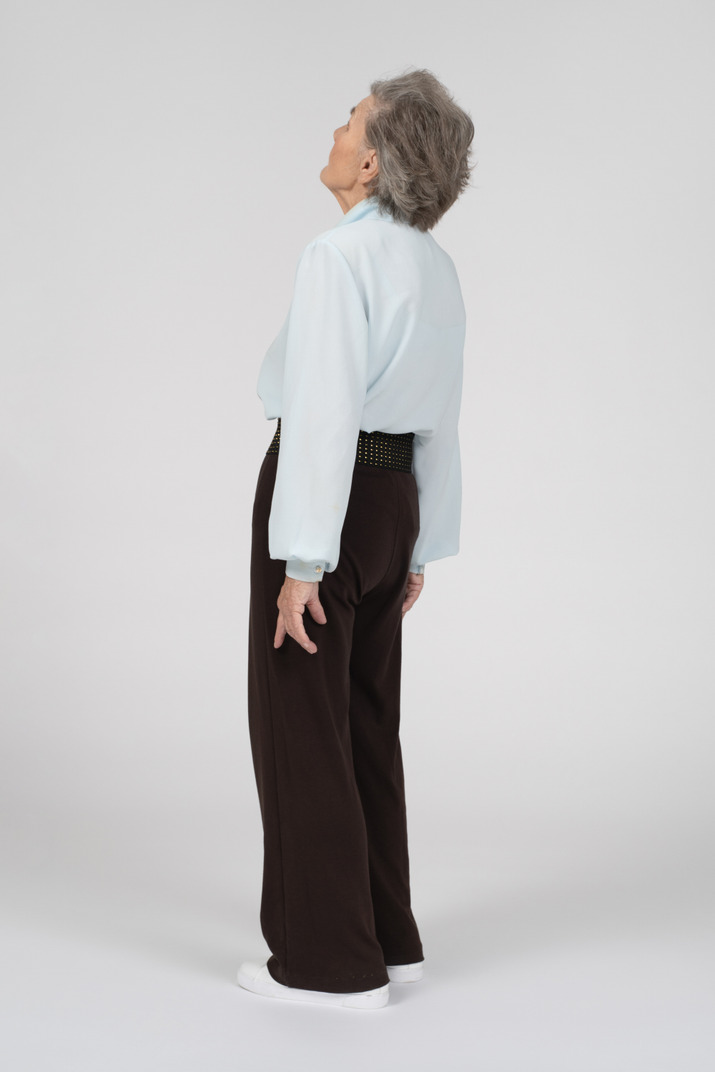 Three-quarter back view of an old woman looking up Photo