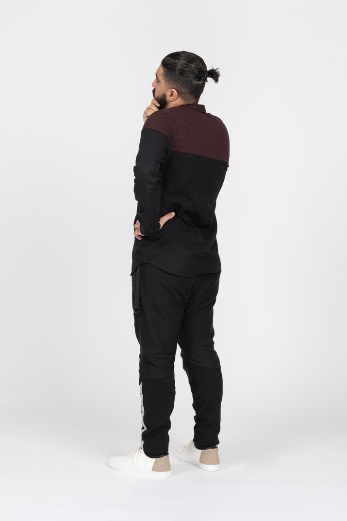 Three quarter back view of young man thinking Photo