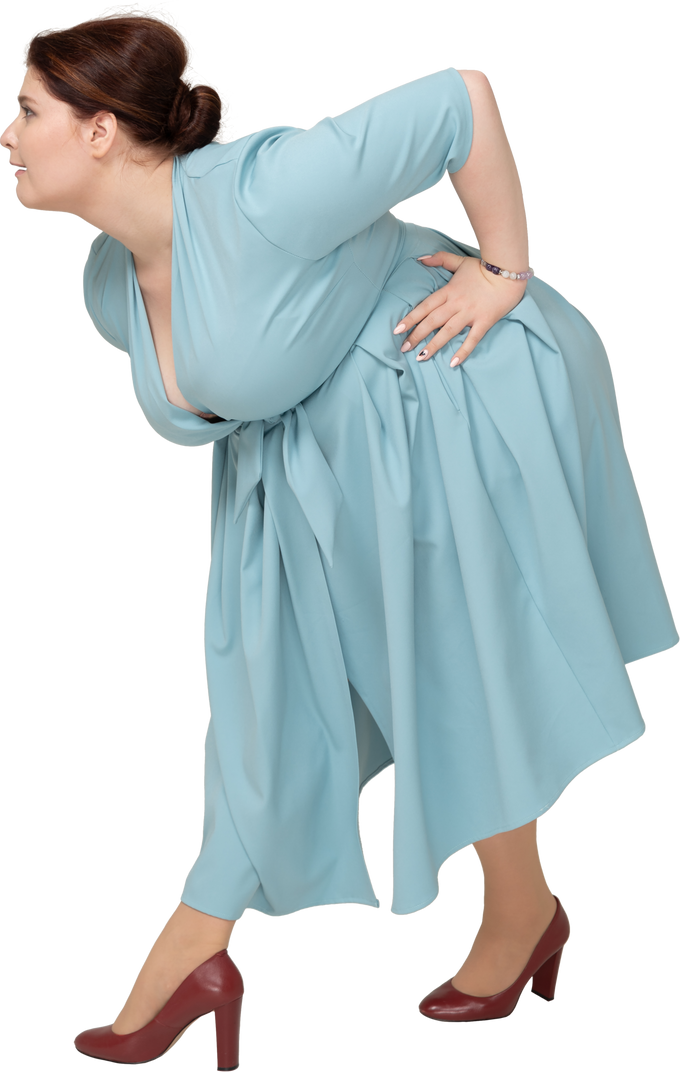 Side view of a woman in blue dress bending down Photo