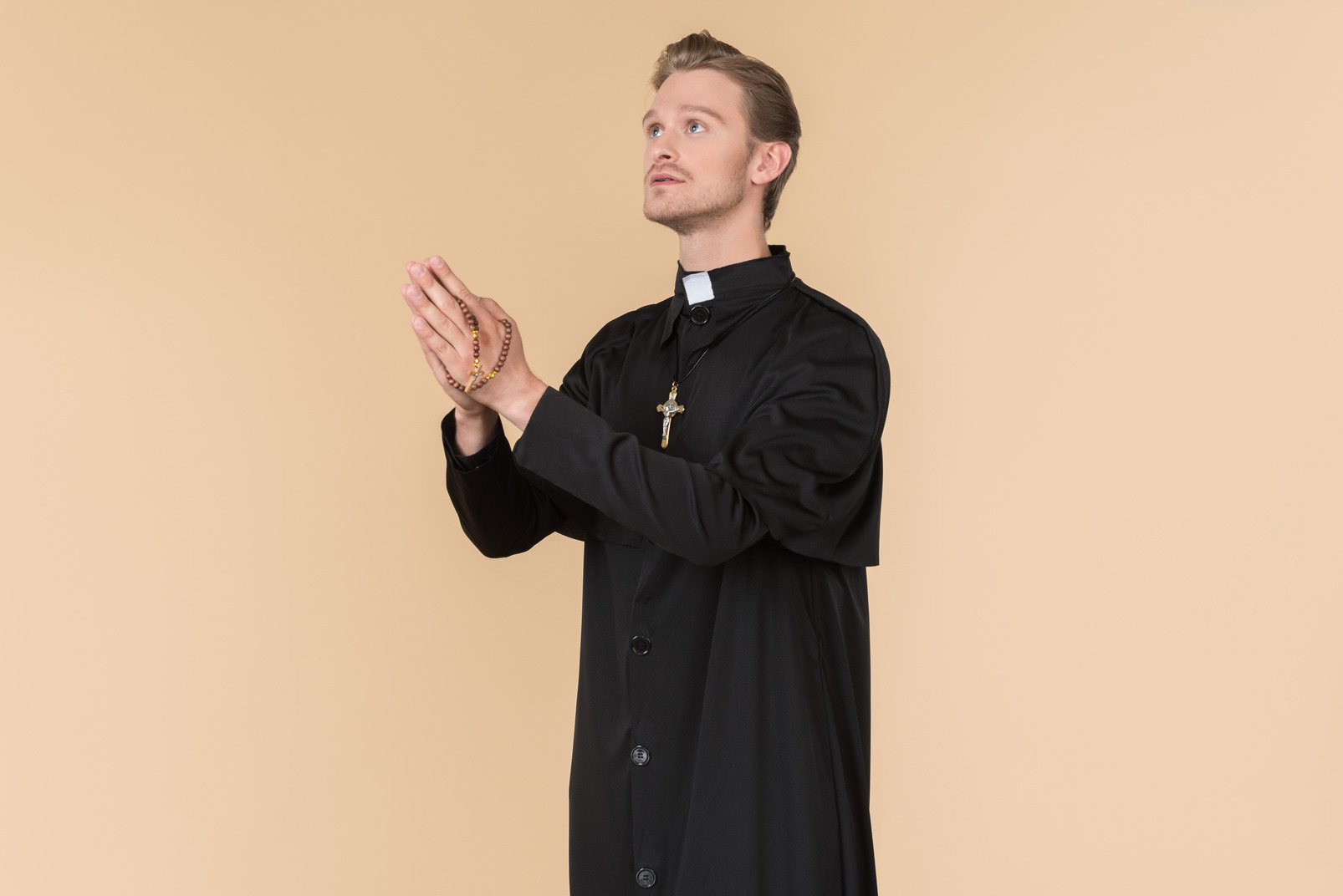 Catholic priest praying using prayer beads Photo