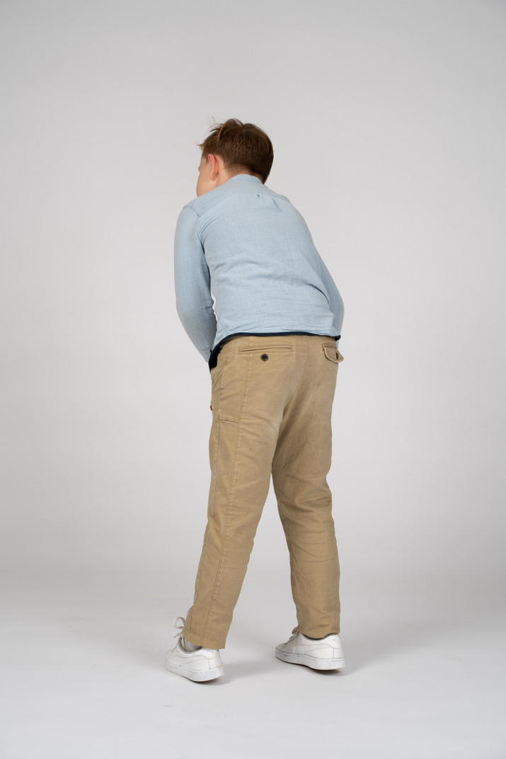 Back view of a boy bending down Photo