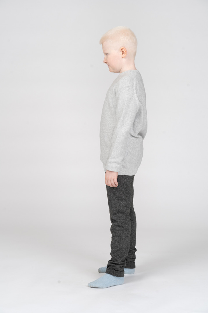 Side view of a little boy standing still Photo