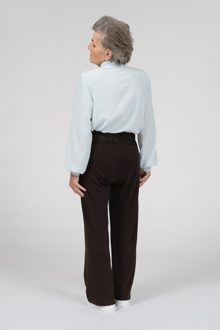 Back view of old lady looking behind back Photo