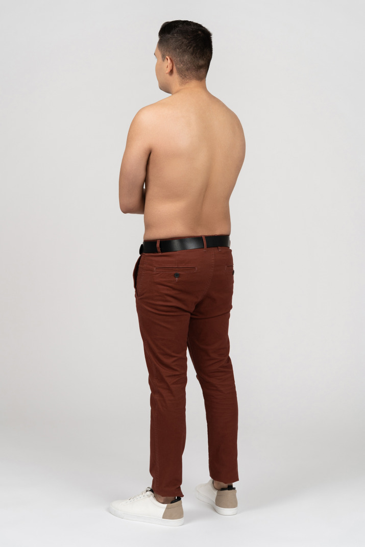 Three-quarter back view of a shirtless latino man with folded hands Photo