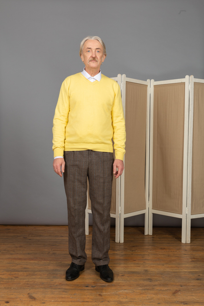 Front view of an old man standing still by the screen Photo