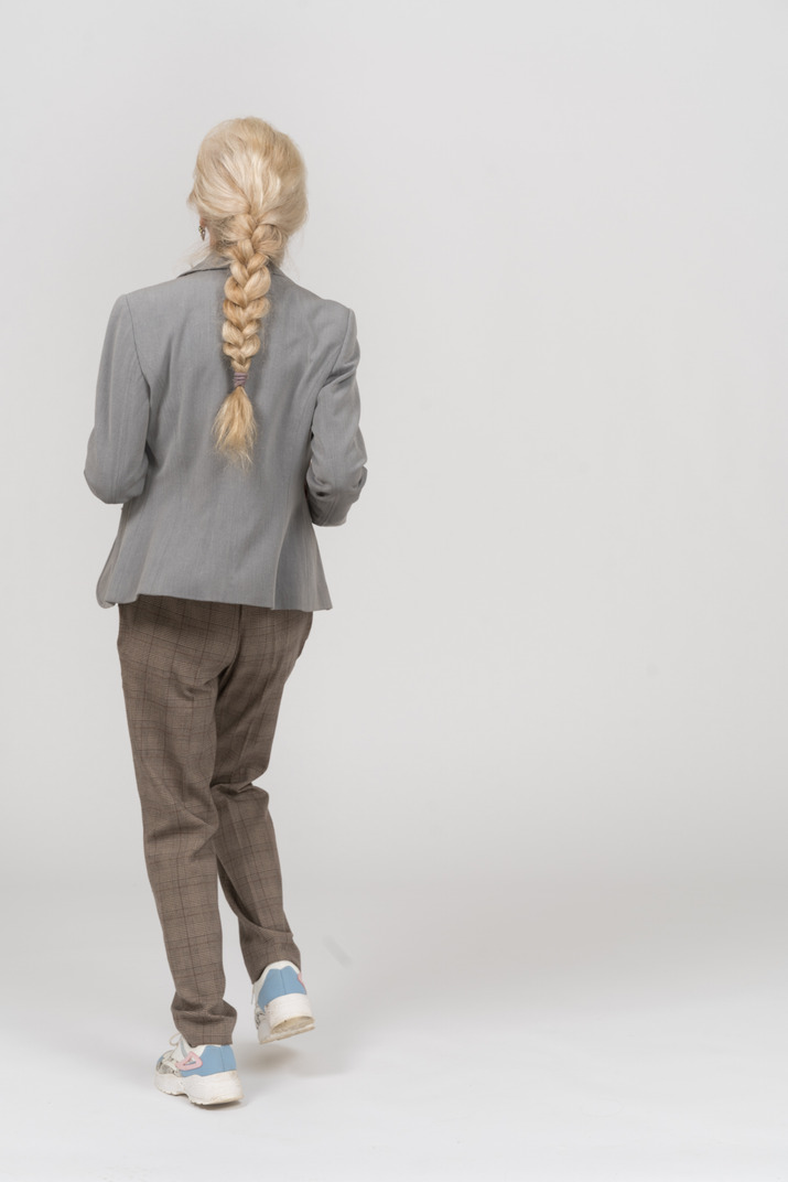 Rear view of an old lady in suit running Photo