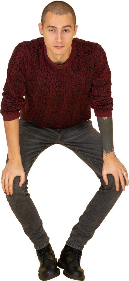 Front view of a serious young man leaning forward and putting hands on ...